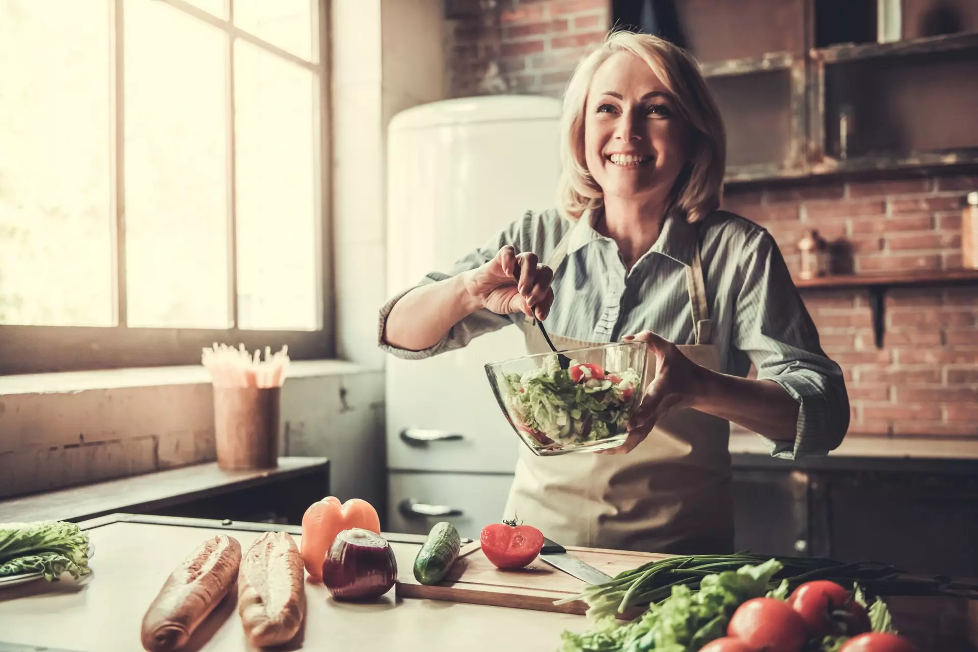 Uma mulher faz uma salada em sua cozinha