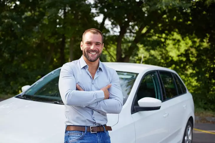 Hombre feliz frente a un auto