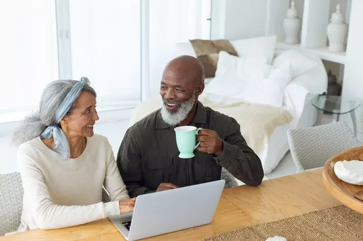 äldre par dricker kaffe på datorn