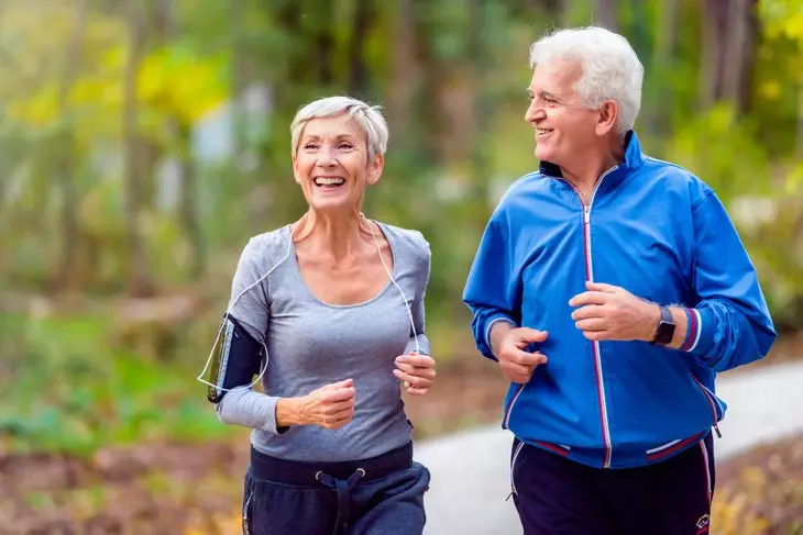 Senior par joggar i parken