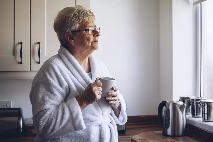 Ledsen äldre kvinna som dricker kaffe