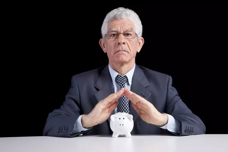 Senior businessman nrog piggy bank