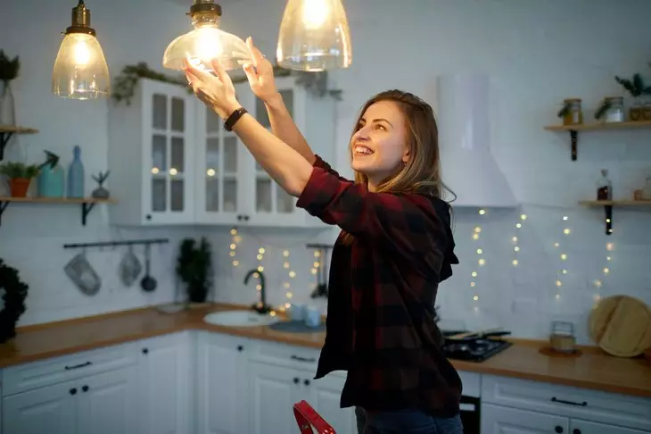 Donna che cambia una lampadina