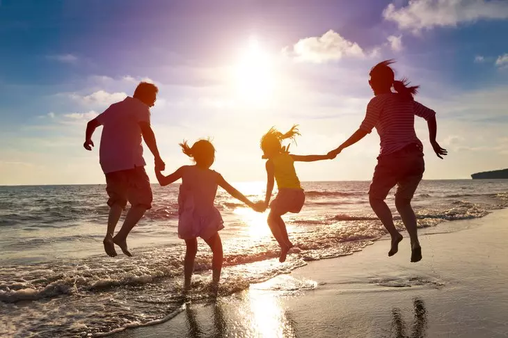 Família brincando na praia, silhueta