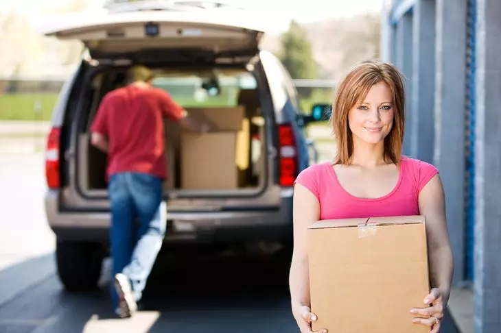 Coppia che scarica un minivan con box presso l'unità di noleggio.