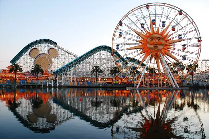 braucieni Paradise Pier Anaheim Kalifornijas atspoguļots ezers