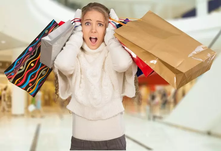 Mujer de aspecto frenético con bolsas de compras.