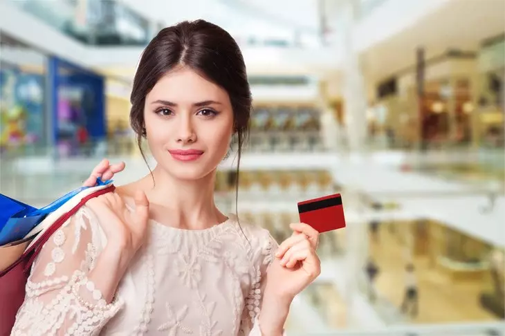 Femme au magasin, tenant une carte.