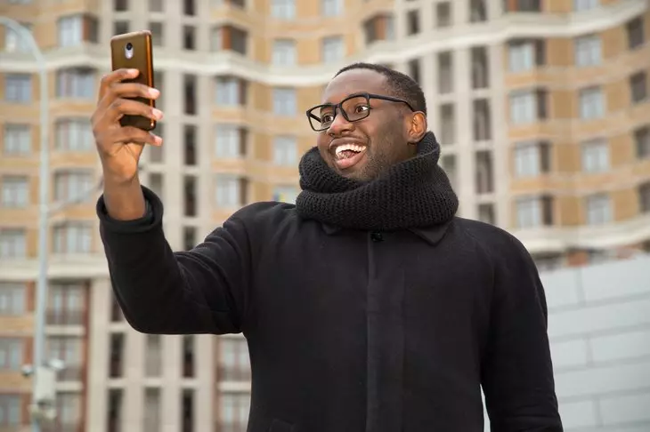 Adam şäher köçesinde selfi edýär.