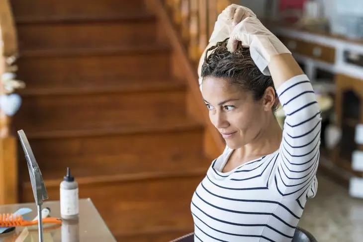 Frau, die sich zu Hause die Haare färbt