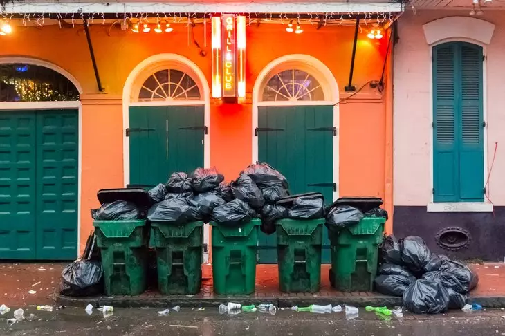 Plné popelnice před jasně osvětlenou výlohou