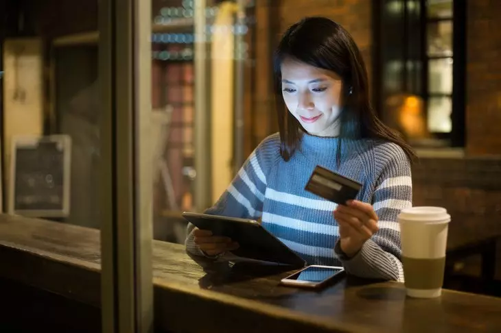 Jonge vrouw die online winkelt.