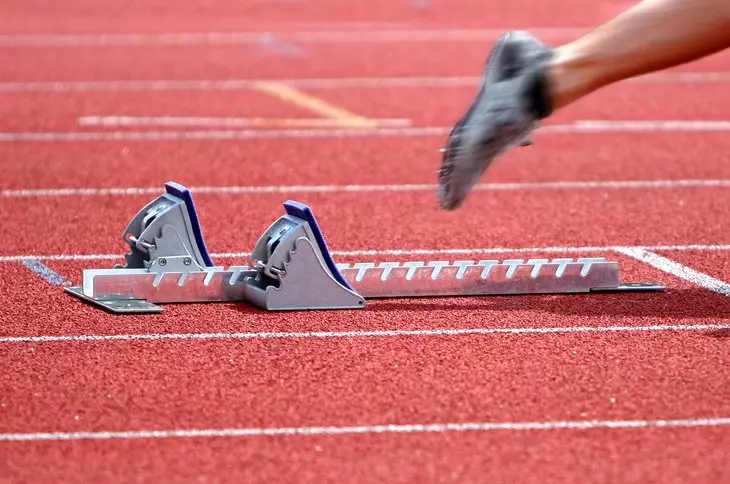 Gros plan sur les pieds d'un sprinteur au départ de la course.