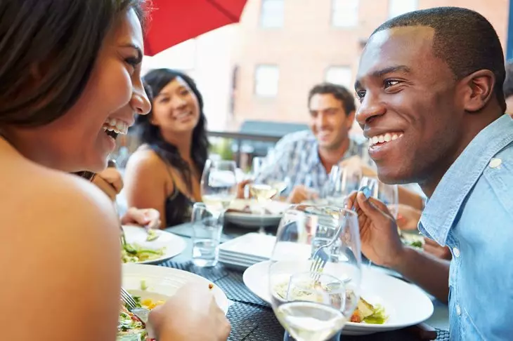 Un grupo de amigos come nun restaurante fóra