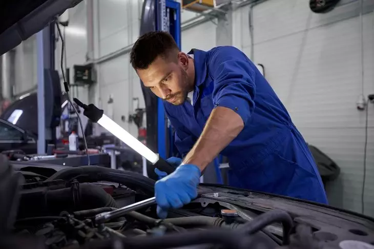 Automonteur wurket oan in auto