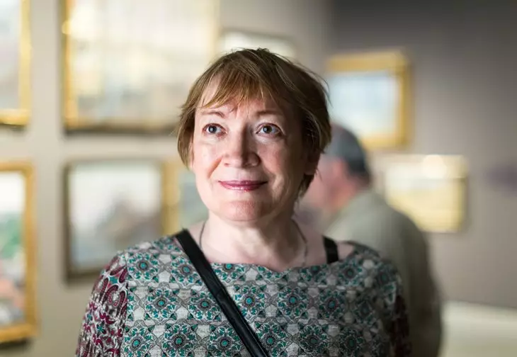 In senior frou sjocht skilderijen yn in keunstmuseum