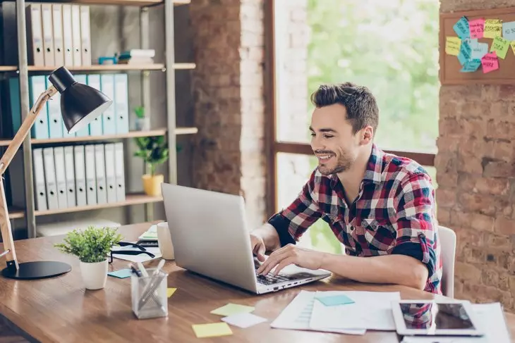 Man aan het werk in kantoor aan huis op laptop