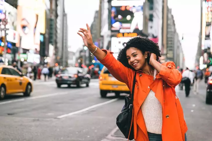 Dona marcant un taxi a Nova York.