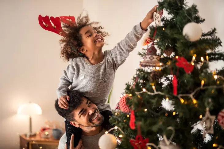 Vater und Kind schmücken einen Weihnachtsbaum