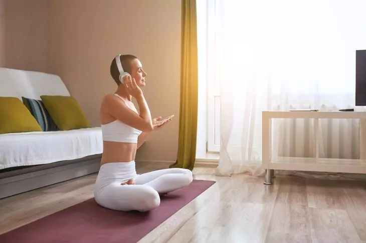 mujer sentada en una estera de yoga