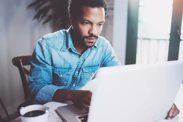 Afro-Amerikaanske man dy't wurket op laptop