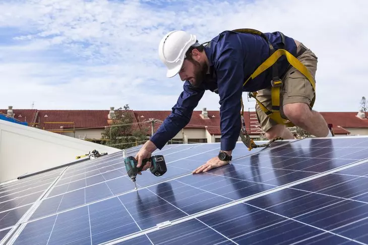 Aarbechter installéiert Solarpanneauen