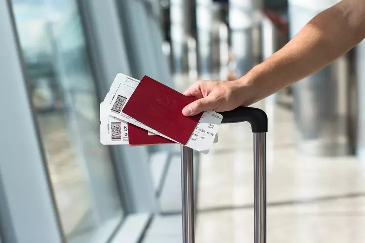 Reesender hält Boarding Pass a Päss um Fluchhafen