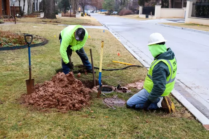 Muncitori care repară o scurgere de conductă