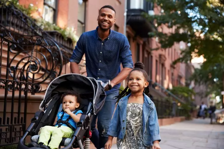 papá Padre y dos hijas dando un paseo por la calle negro afroamericano