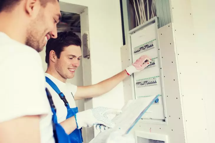 Hombres que miran el panel eléctrico