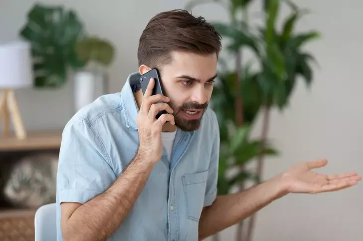 Un uomo infastidito discute al telefono