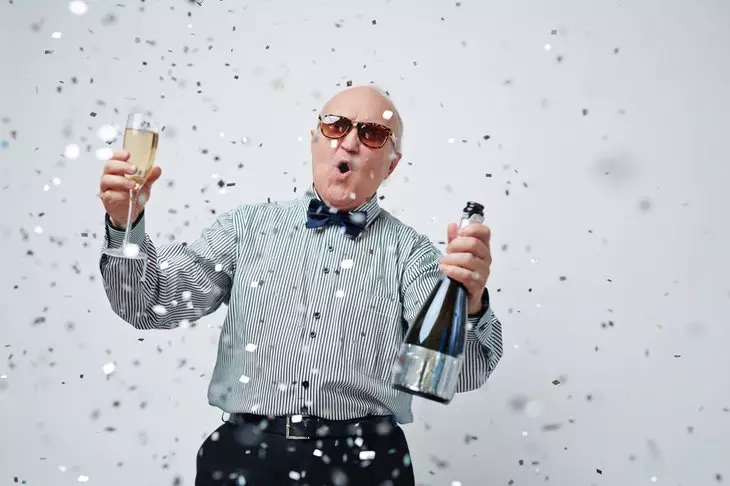 Un senior heureux célèbre avec du champagne