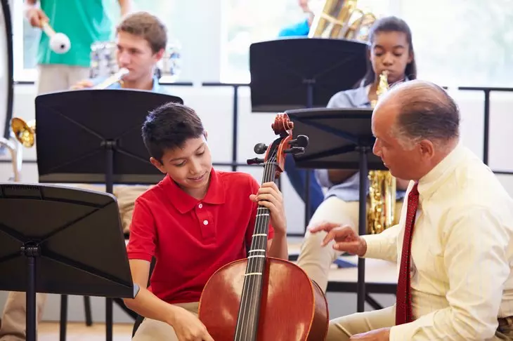 Alumnos tocando instrumentos co profesor na clase de música