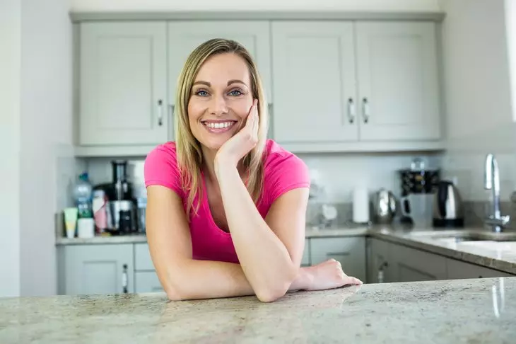 Mujer frente a gabinetes de cocina