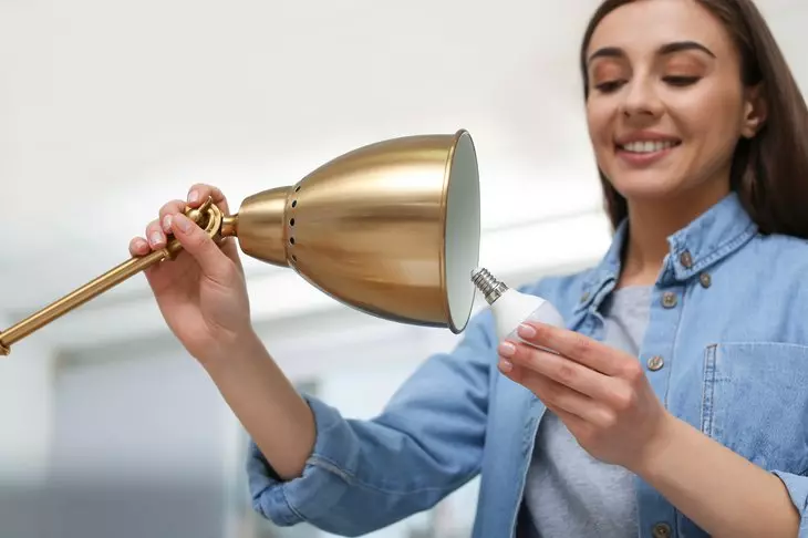 Mujer cambiando bombilla