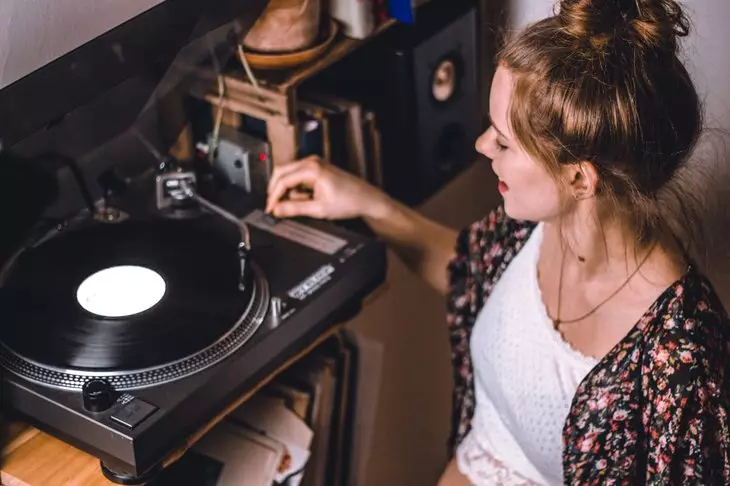 Mulher tocando um disco em uma plataforma giratória