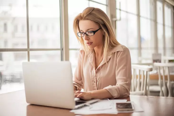 Young businesswoman na nagtatrabaho sa laptop sa cafe