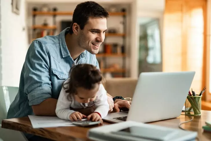 Ayah bekerja dari rumah di laptop dengan anak perempuannya