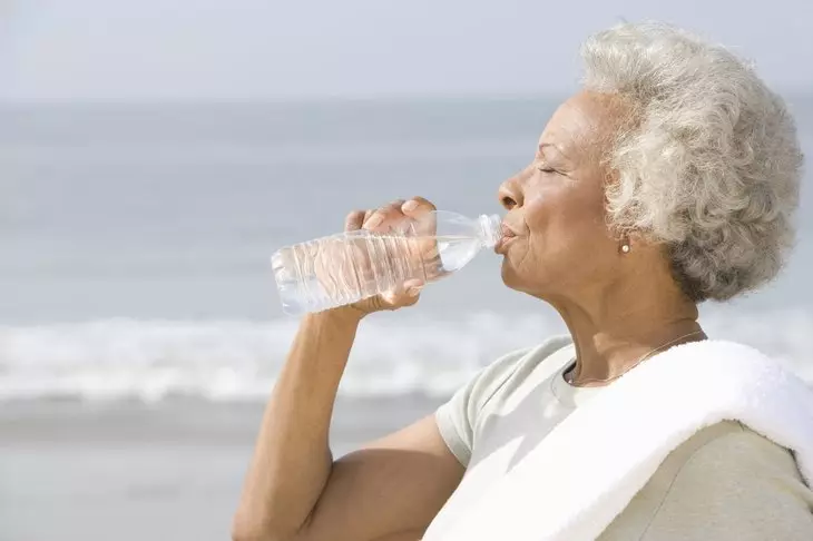 Vrou wat gebottelde water drink