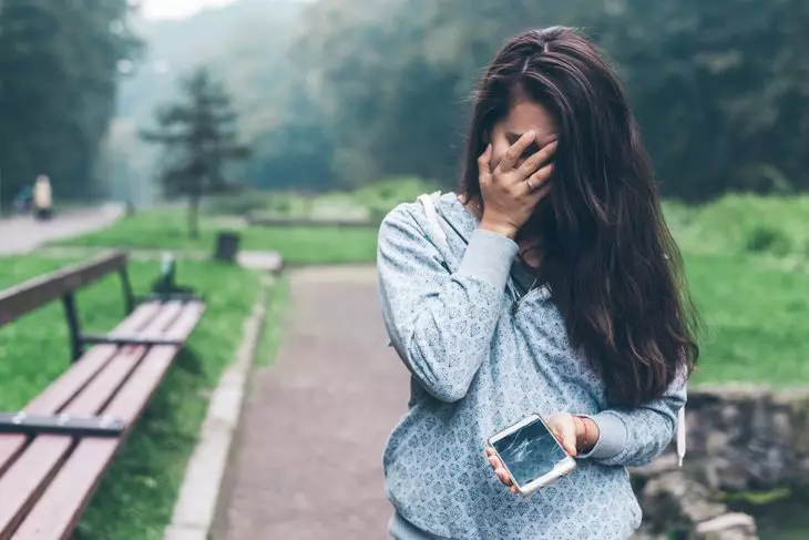 女人對破裂的手機感到不安