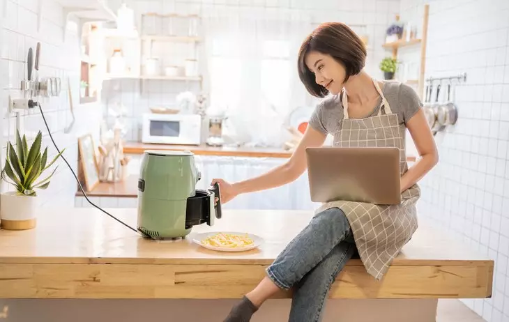 Mulher cozinhando com fritadeira