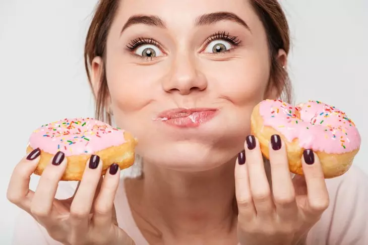 Mulher comendo rosquinhas vitrificadas