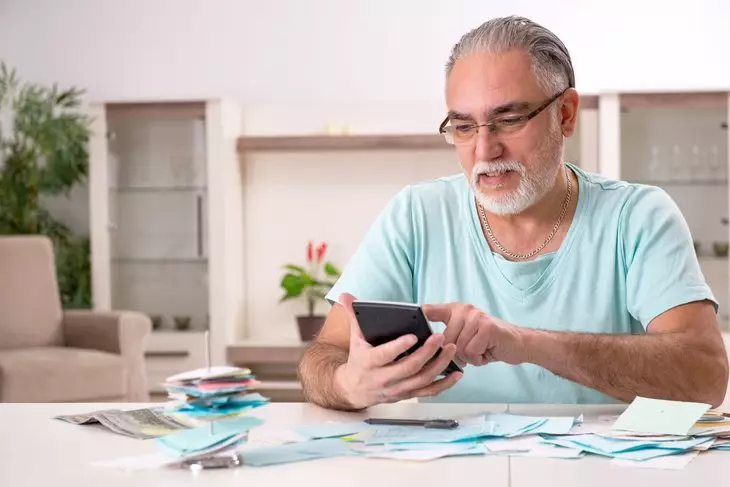 Stresszes nyugdíjas, aki költségvetést készít és számlákat fizet