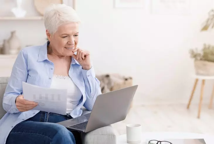 senior frau weiß graue haare couch knirschen zahlen computer