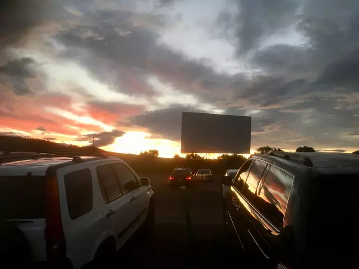 Coches estacionados nun drive-in-teatro durante o solpor