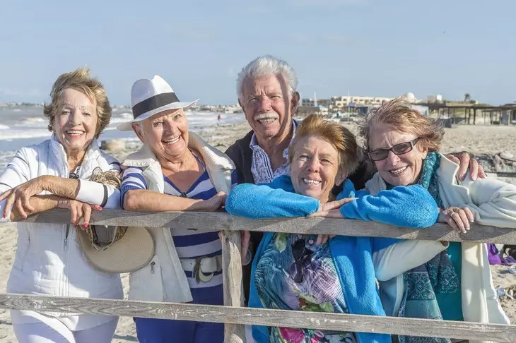 Grupp seniorer på stranden.