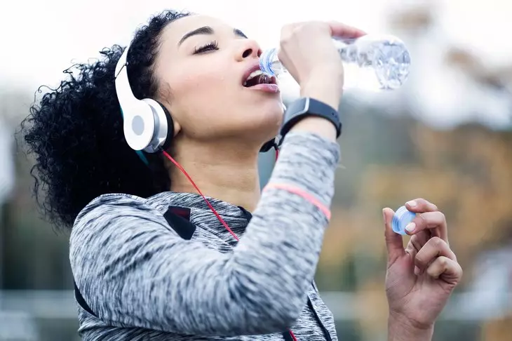 Wanita ngombe banyu saka botol