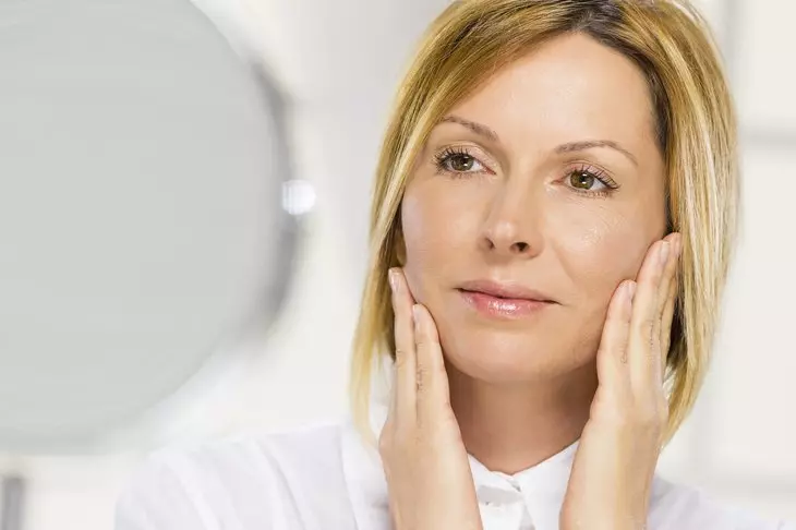 Femme appliquant des cosmétiques sur son visage