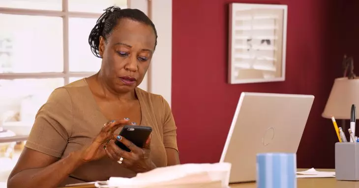 Femme afro-américaine travaillant sur ordinateur à la maison.