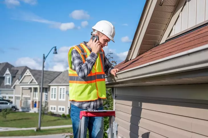 Trabajador inspeccionando el techo de una casa